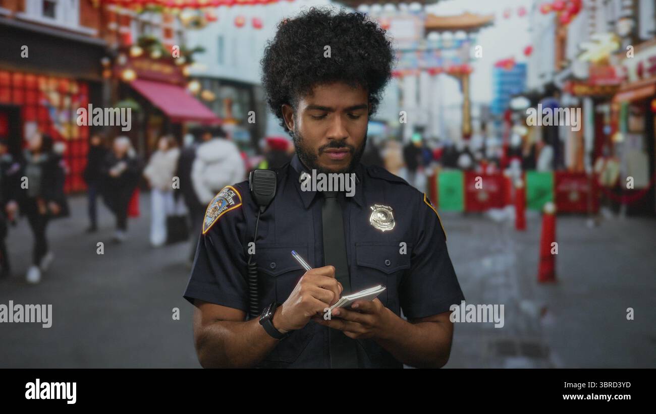 Police officer writing in notepad on busy city street with blurred ...