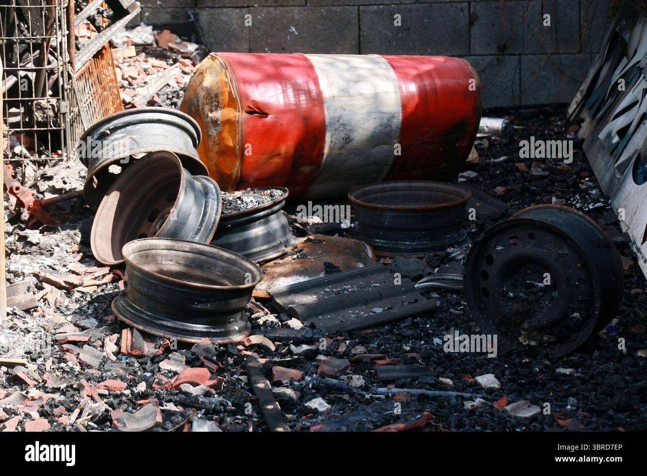 A pile of rusted car parts and a red and white barrel Stock Photo - Alamy