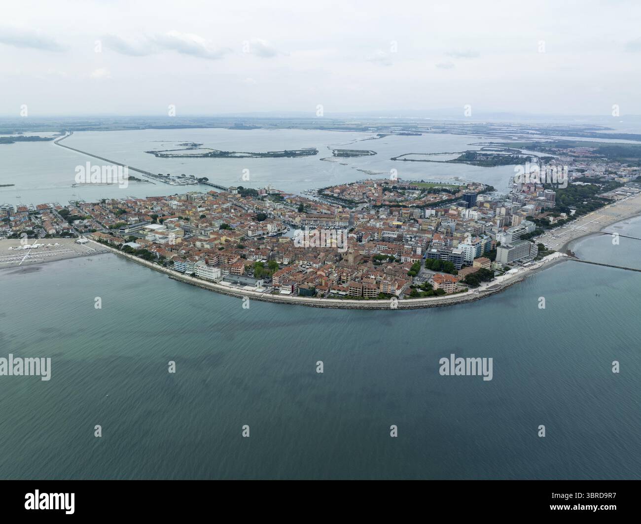 Aerial view of a coastal town with terracotta roofs meeting the ...