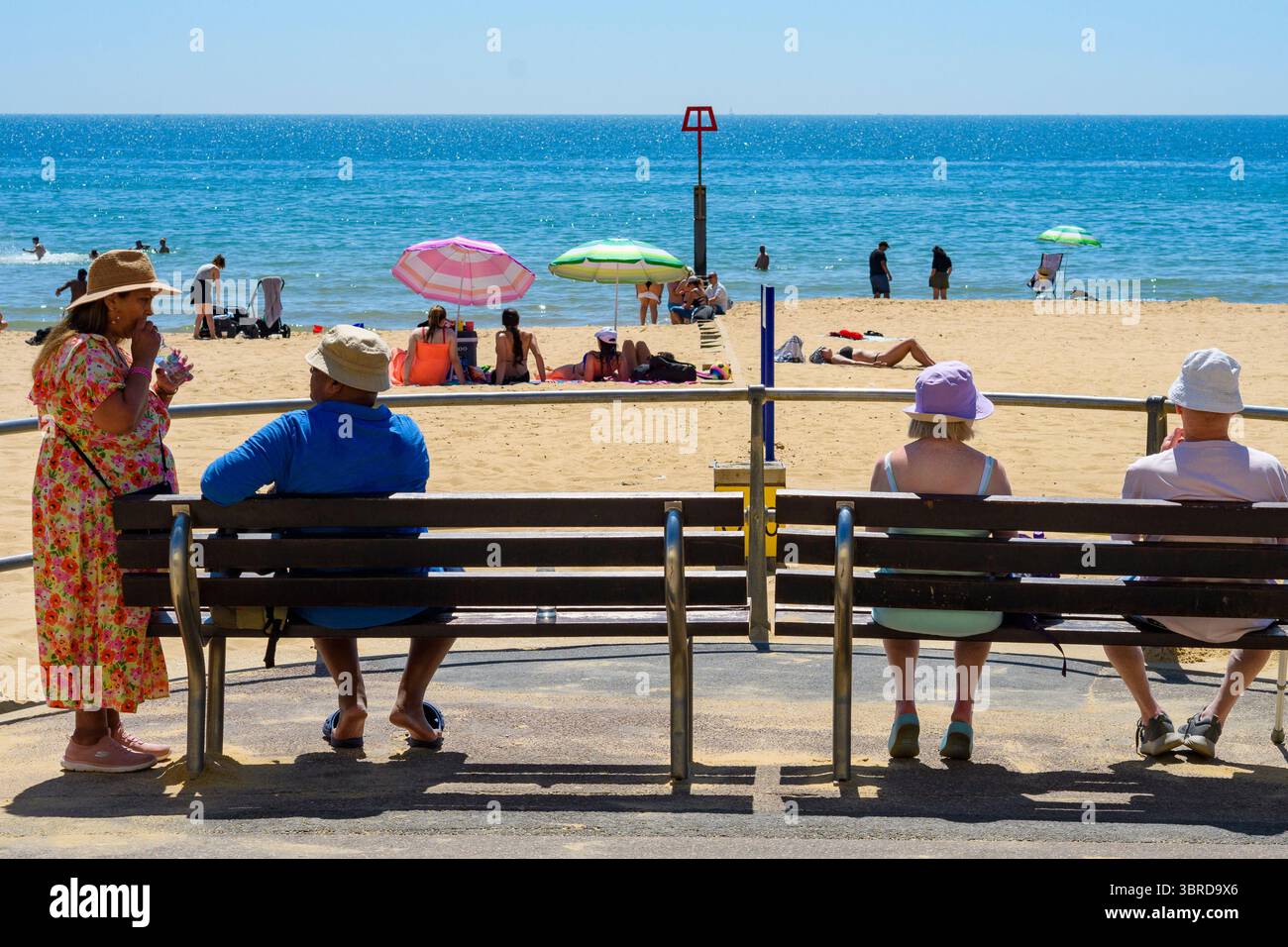 Heatwave, Bournemouth, July, 2025. People sitting on seafront bench and ...