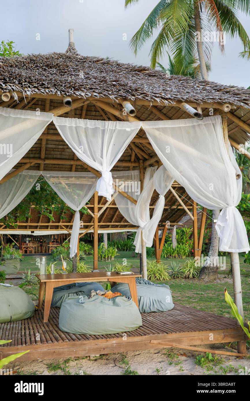 A beautiful beachfront setting in the garden with wooden table, bean ...