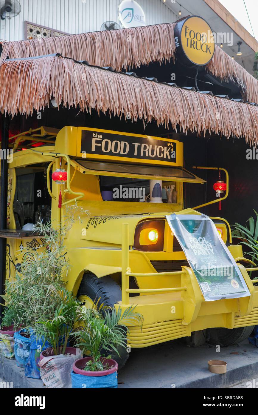 A yellow food truck in a local restaurant in Asia with wood and bamboo ...