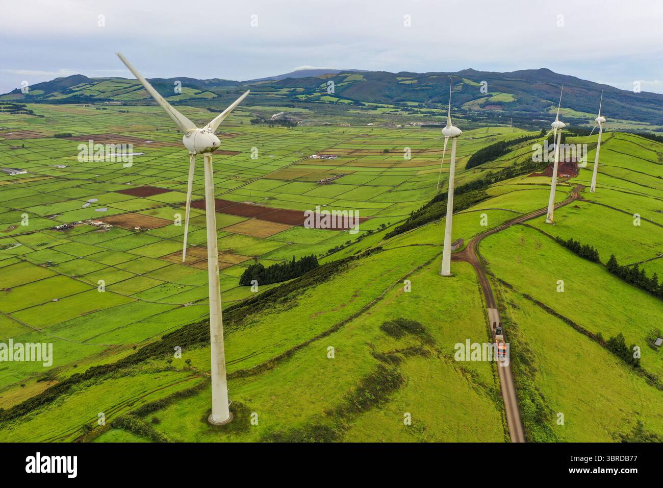 Aerial view of towering wind turbines standing sentinel on a vibrant ...