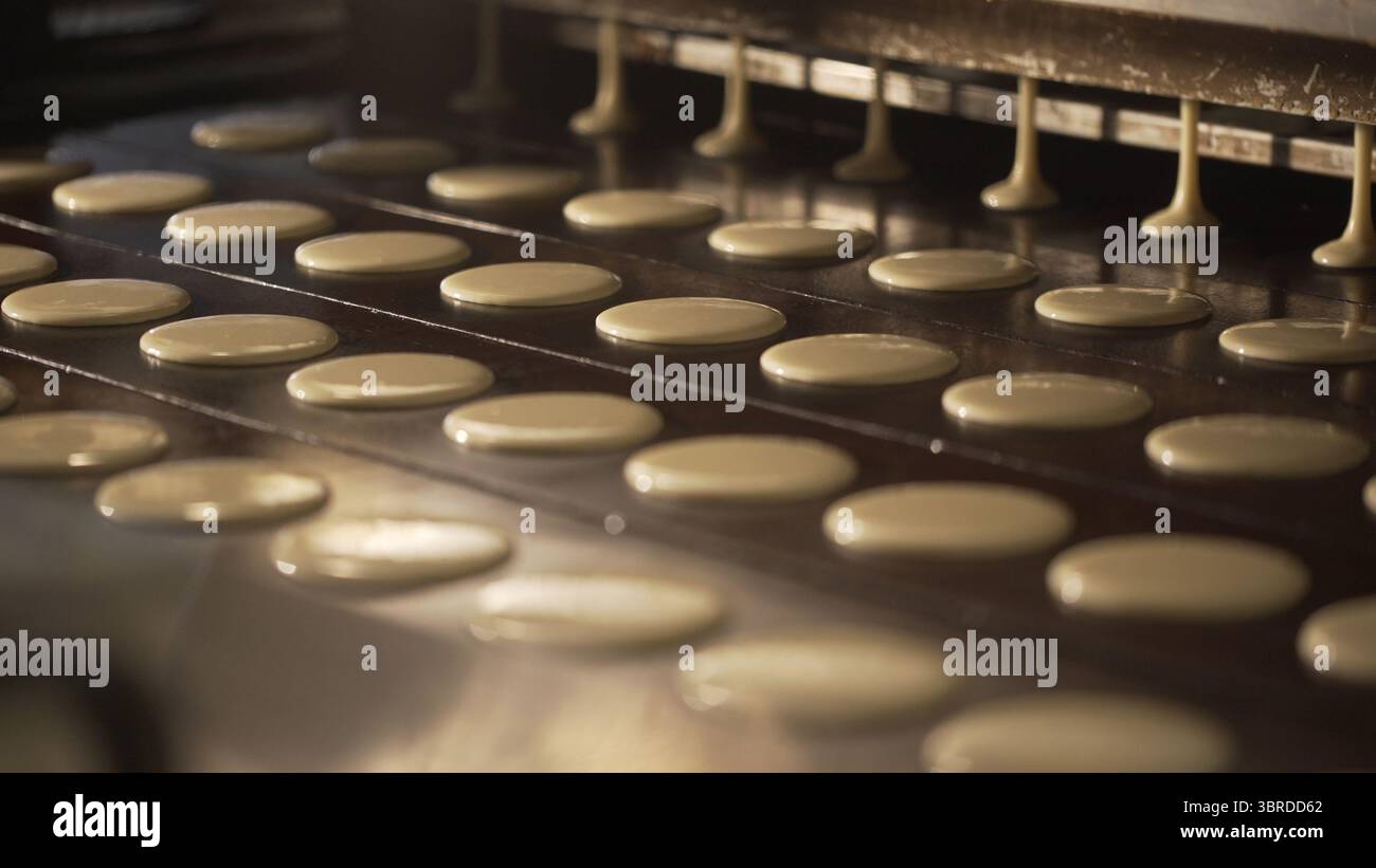 Machine pouring batter onto a conveyor belt creates perfectly shaped ...