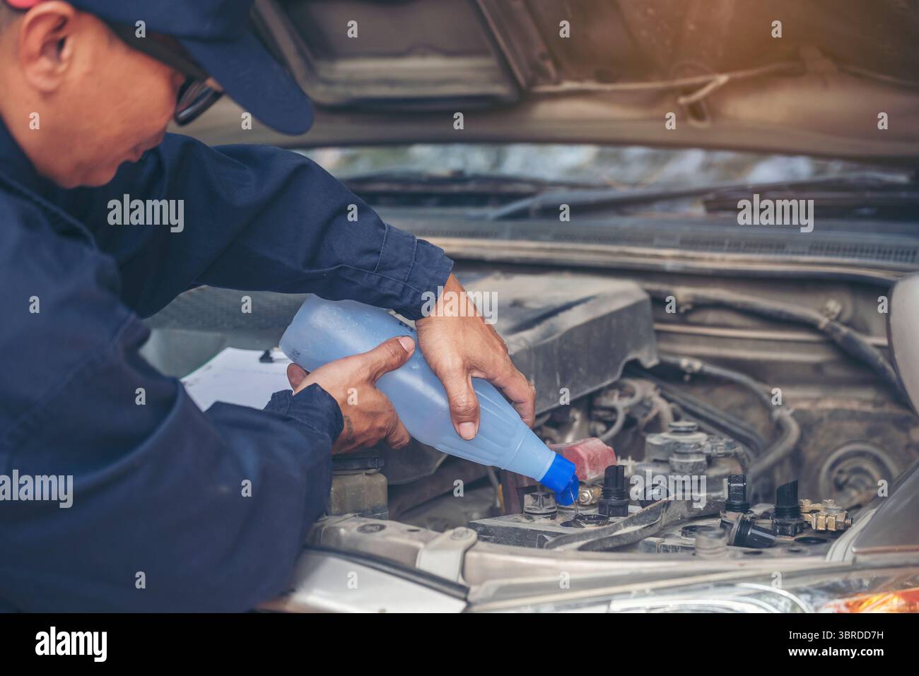 Car Mechanic man hands pouring Deionized purified Distilled water for ...
