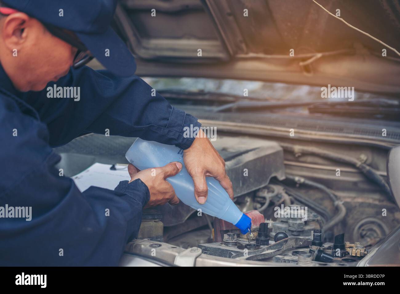 Car Mechanic man hands pouring Deionized purified Distilled water for ...