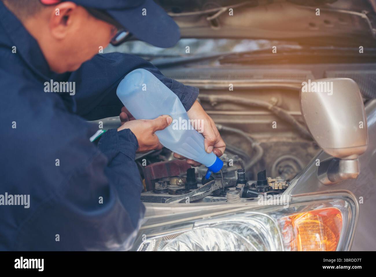Car Mechanic man hands pouring Deionized purified Distilled water for ...