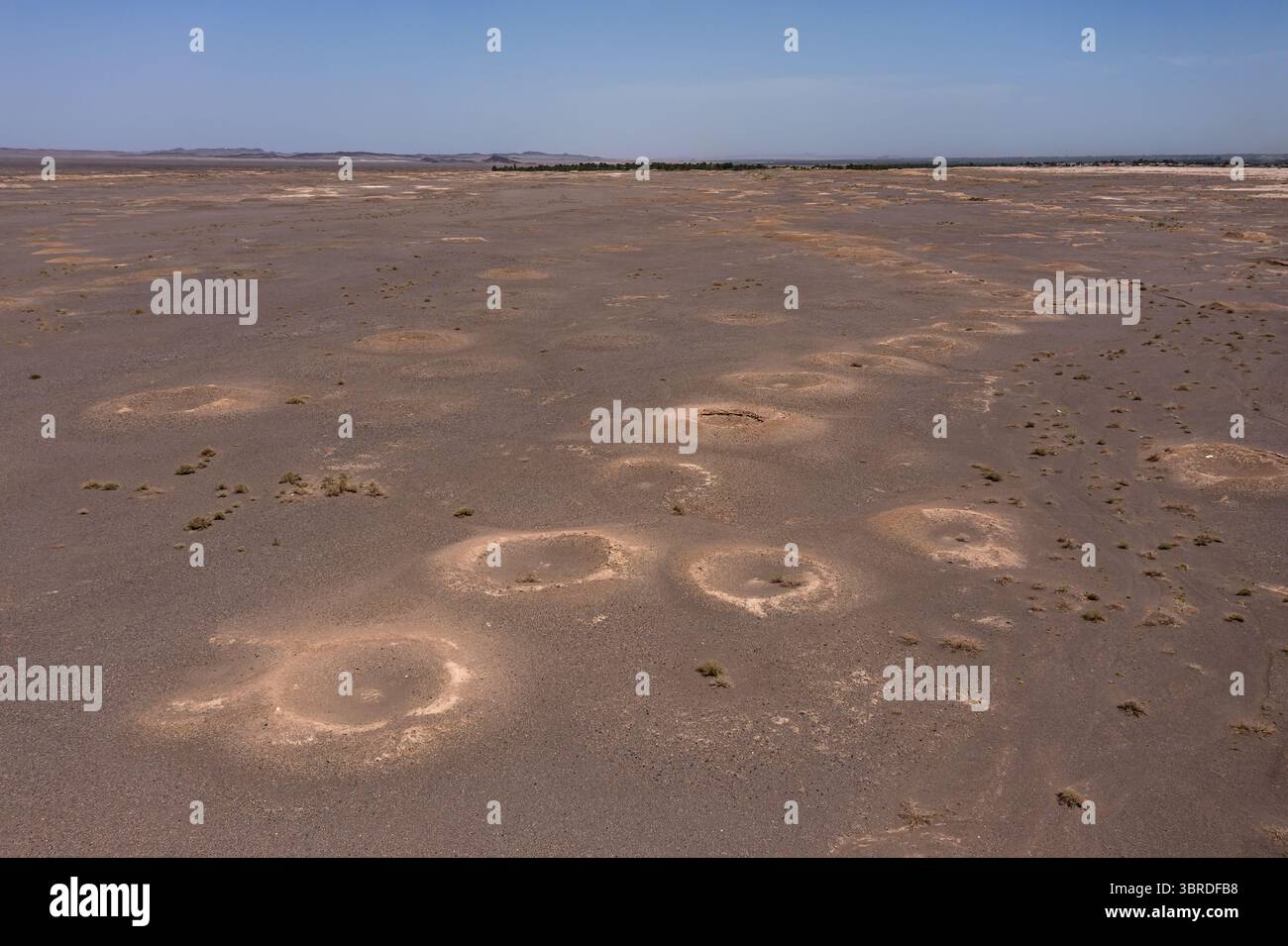 Aerial view of the arid landscape reveals circular depressions in the ...