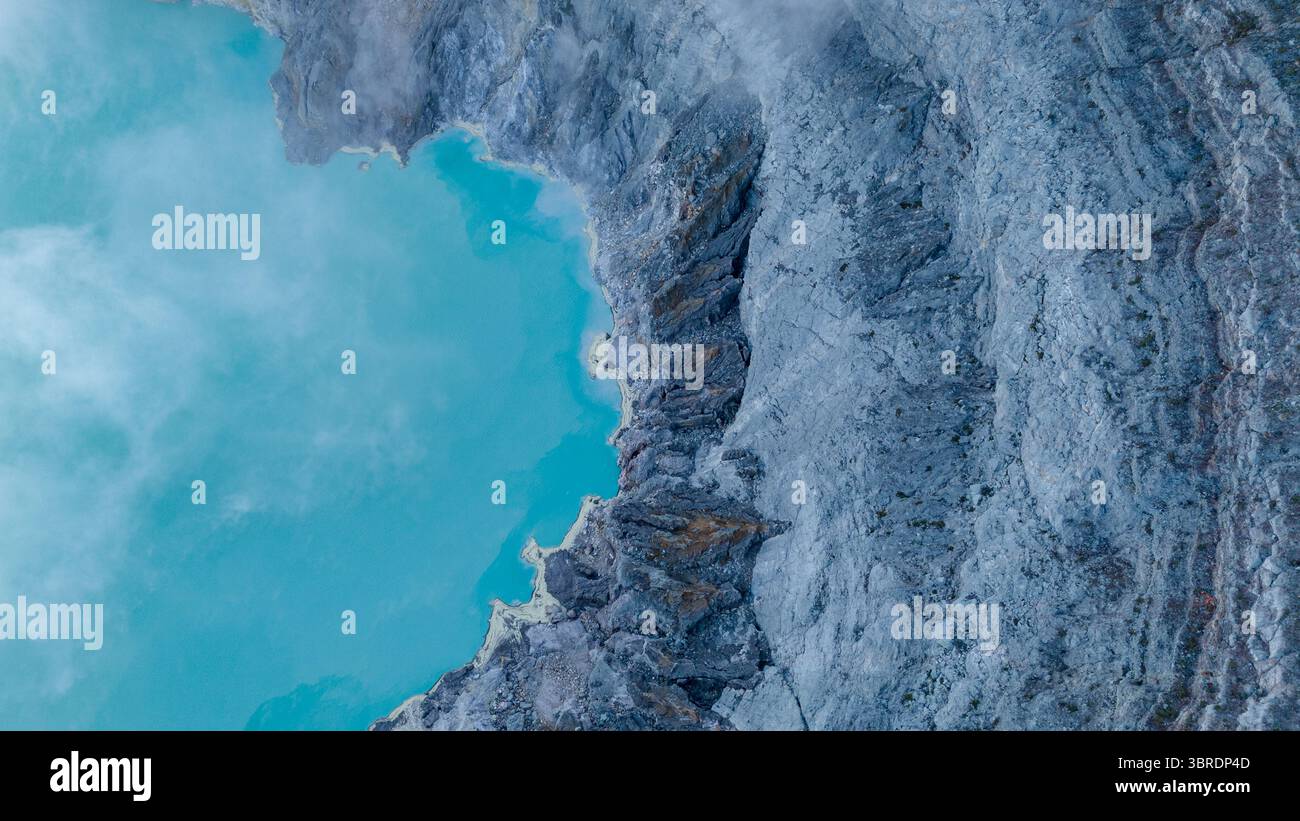 Aerial view of the turquoise lake nestled beside the rugged cliffs of ...
