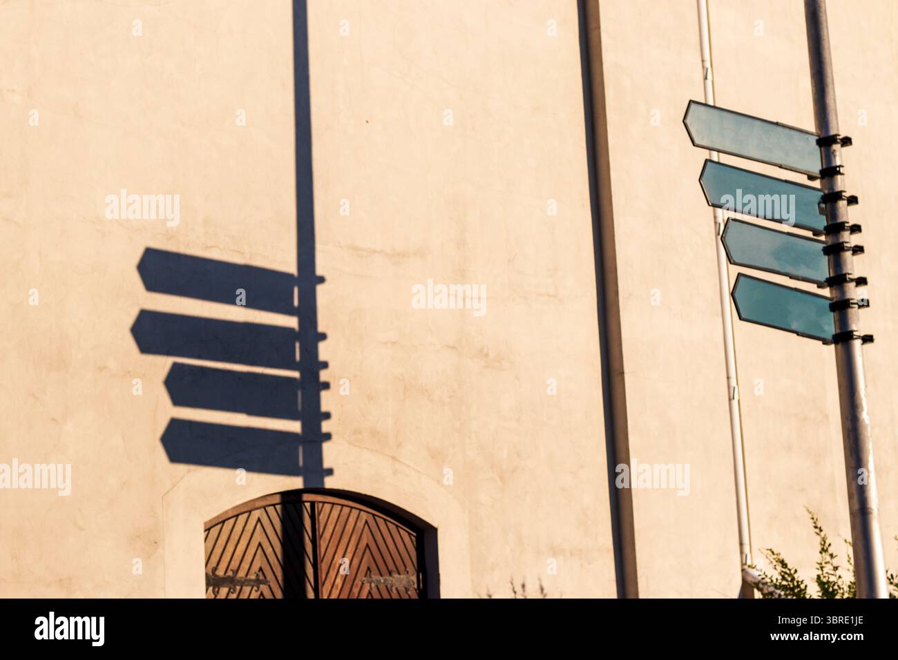 Old style direction signs casting shadow on near by wall Stock Photo ...