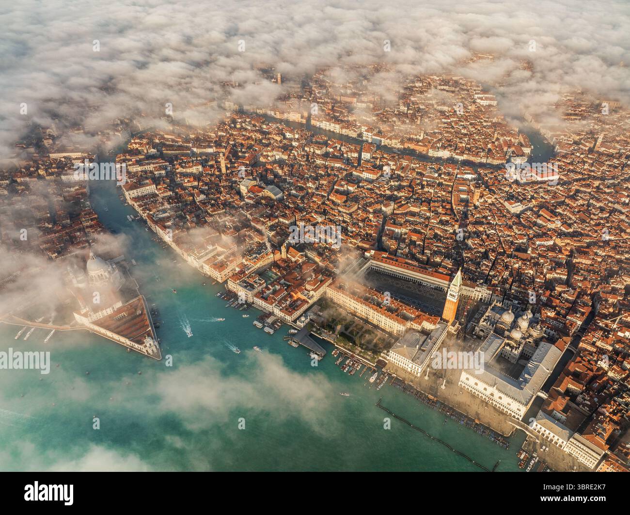 Aerial view of terracotta rooftops and winding canals pierce through a ...