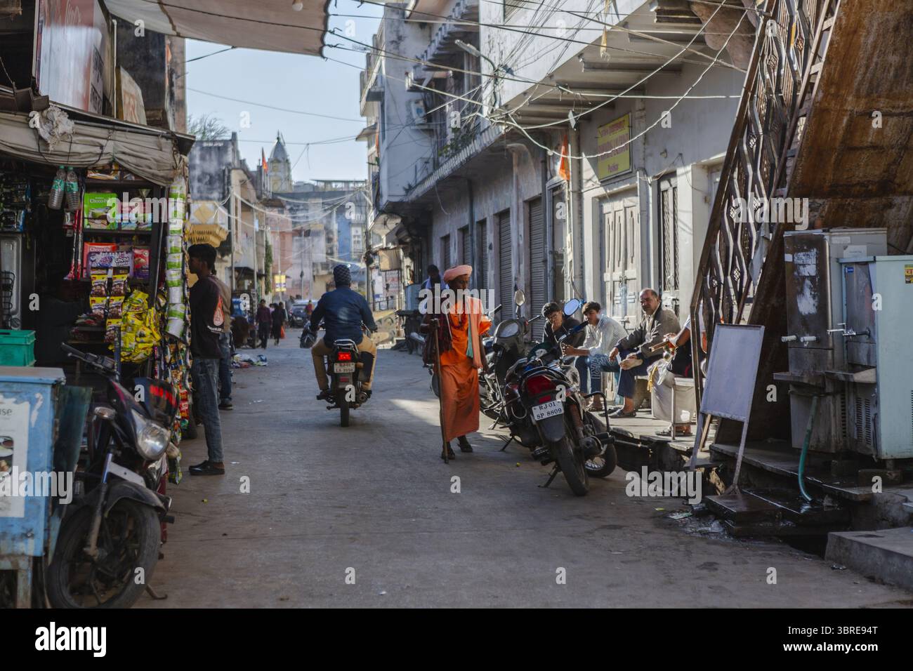 Pushkar, India - 24 June 2025: View of the vibrant street scene with people walking and riding ...
