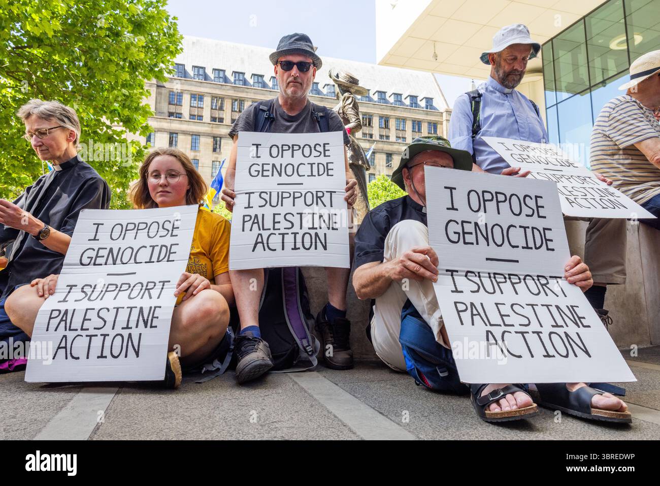 Manchester, UK. 12 JUL, 2025. People hold signs prior to arrests at a ...