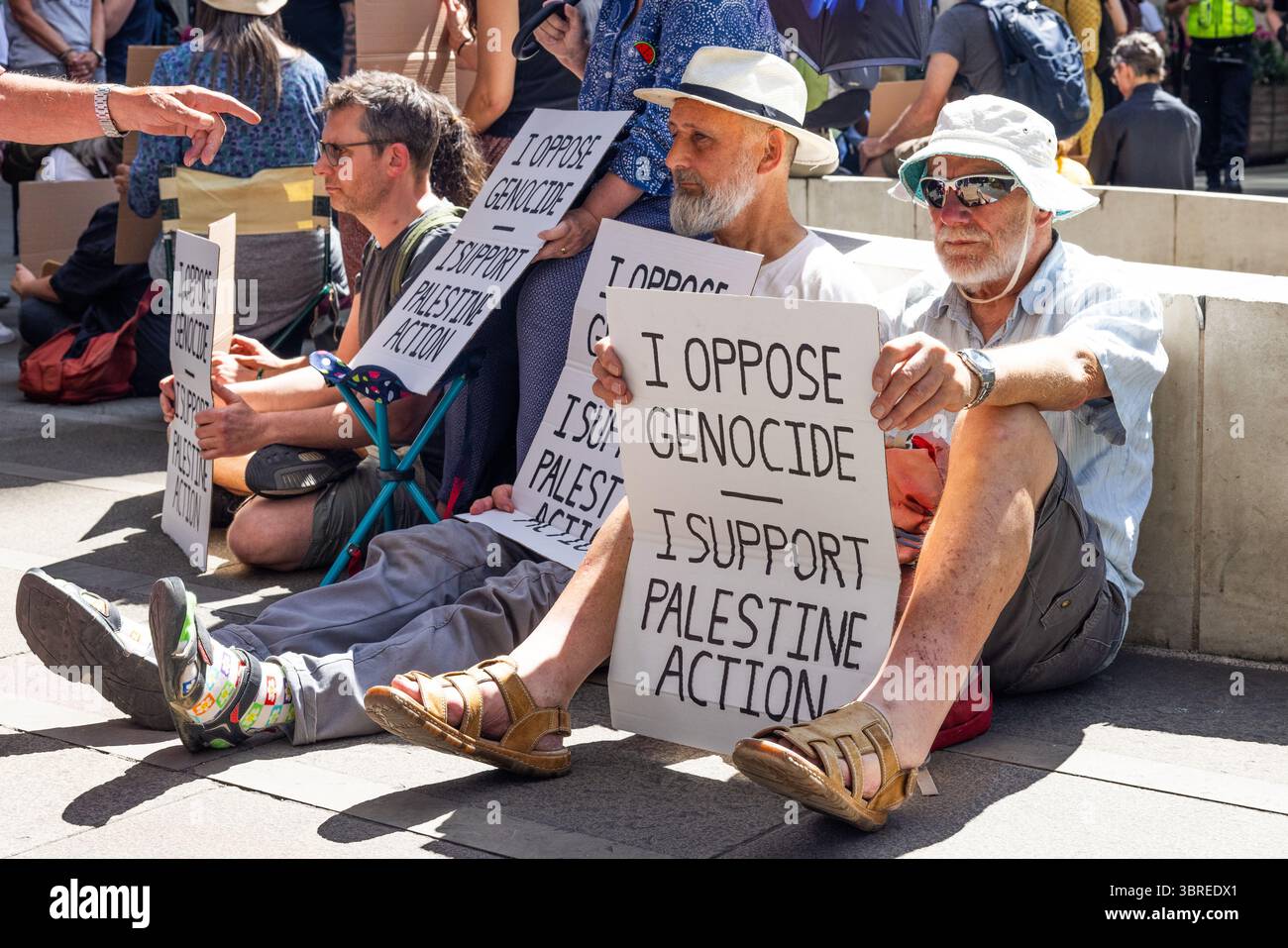 Manchester, UK. 12 JUL, 2025. People hold signs prior to arrests at a ...