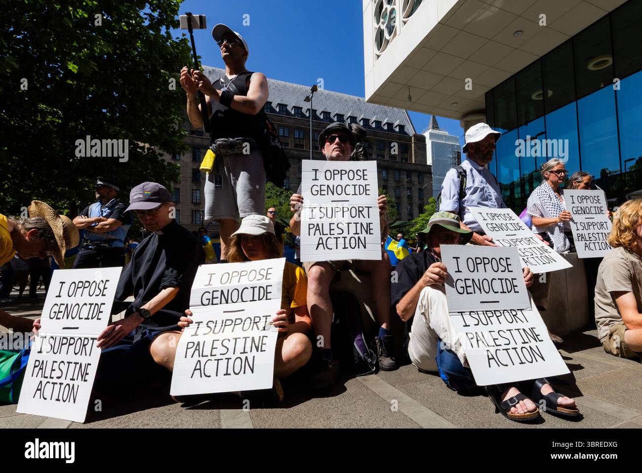 Manchester, UK. 12 JUL, 2025. People hold signs prior to arrests at a ...
