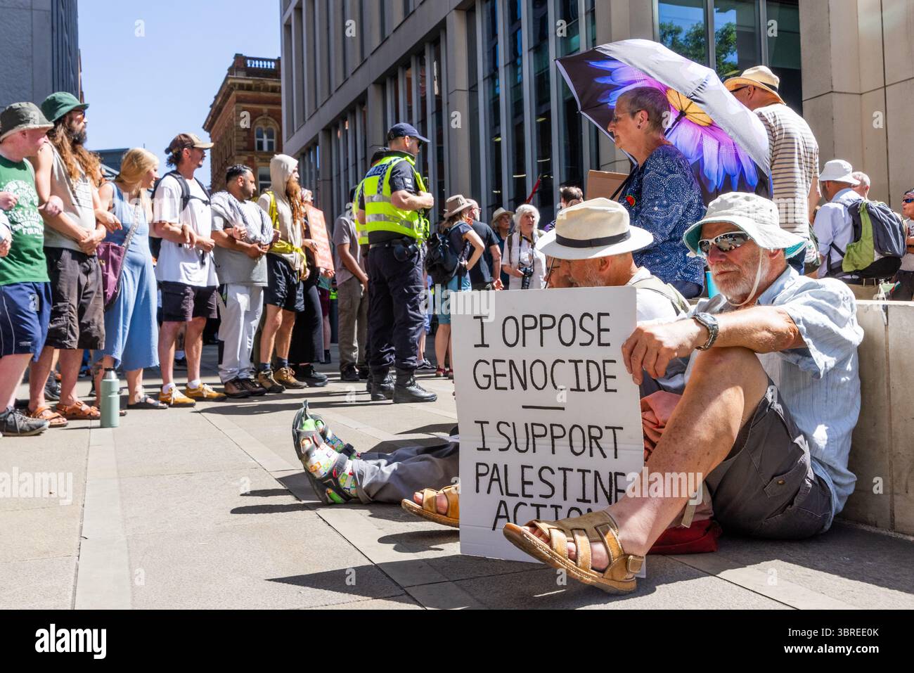 Manchester, UK. 12 JUL, 2025. People hold signs prior to arrests at a ...