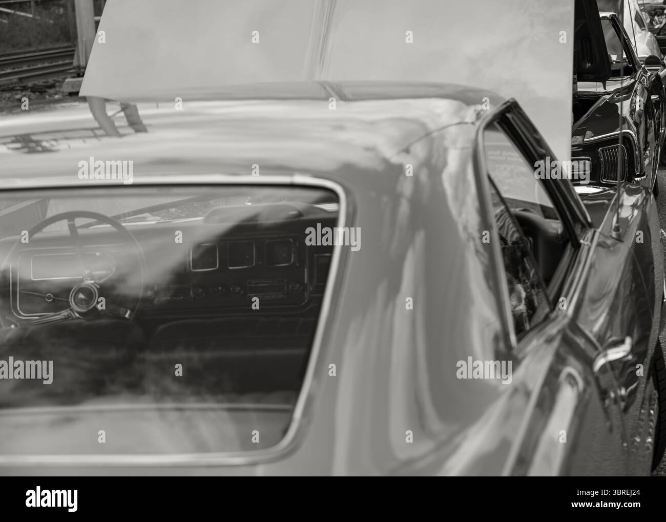 Black and white rear view of a vintage muscle car with raised hood ...