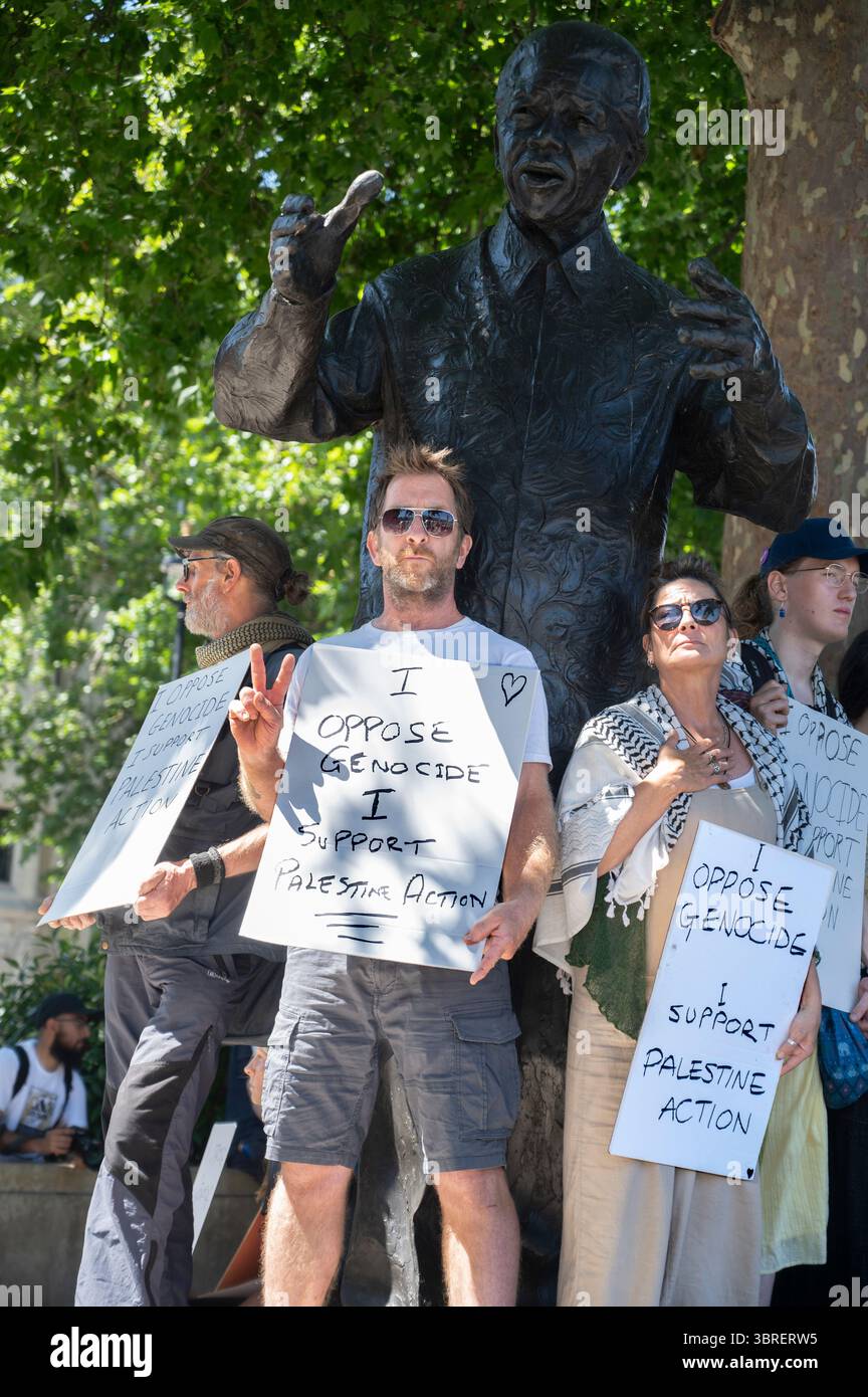 Protesters, several elderly, assemble in front of the statues of Gandhi ...