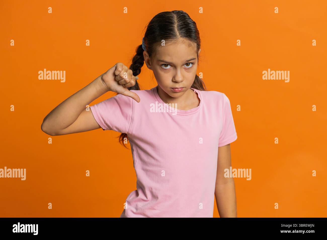 Dislike. Upset young preteen child girl kid showing thumbs down sign ...