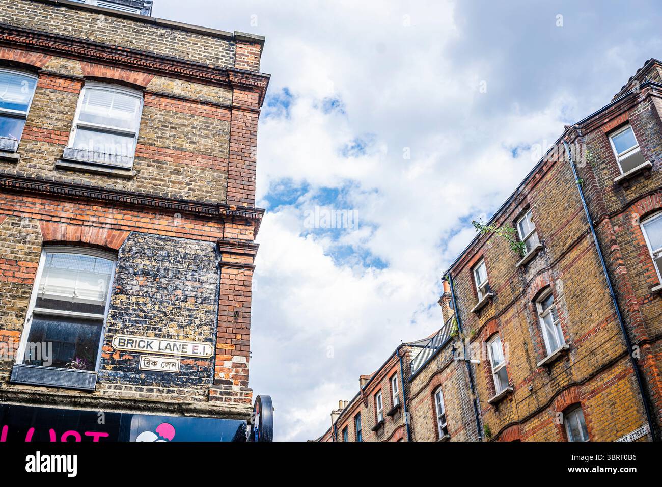 Brick Lane street sign on a brick wall under clear blue sky, iconic ...