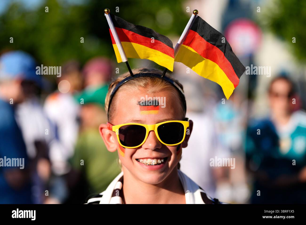 A Germany fan with facepaint and flags in their hair as they arrive to the stadium ahead of the ...