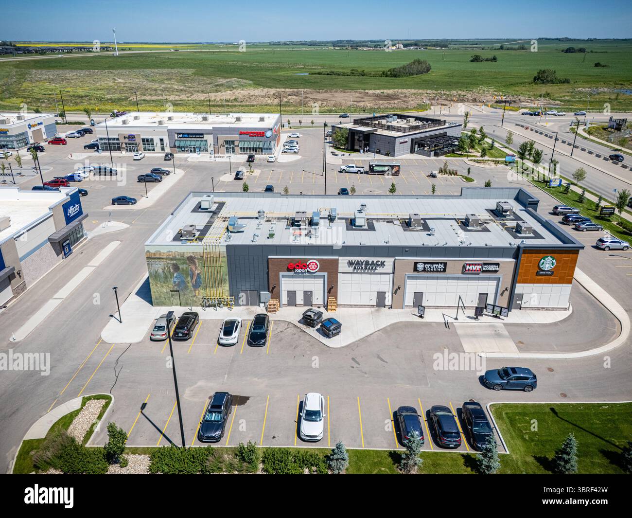 Large building with a red sign on it. The building is surrounded by ...