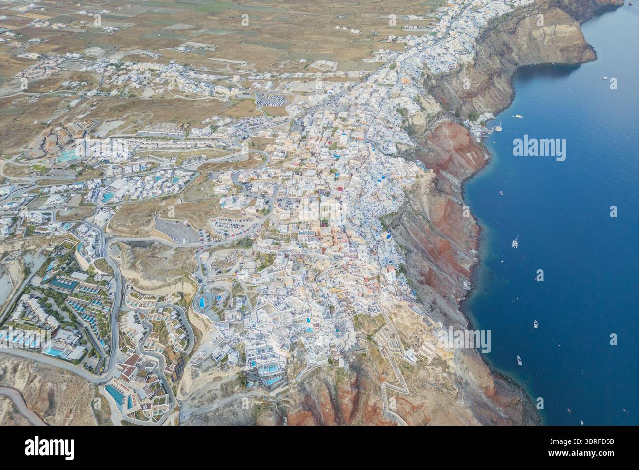 Drone photo of Oia, Santorini showing white houses built on steep ...