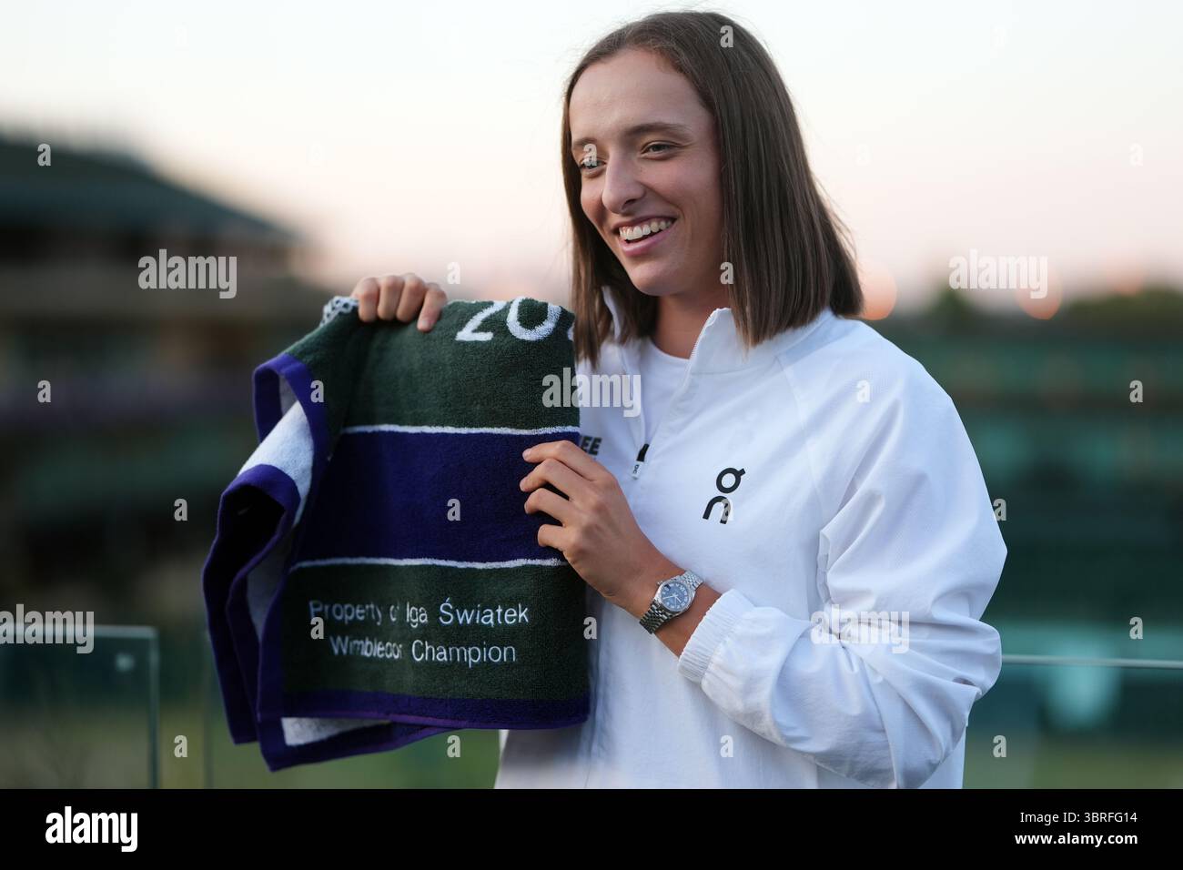 Iga Swiatek holds a personalised Wimbledon towel on day thirteen of the ...
