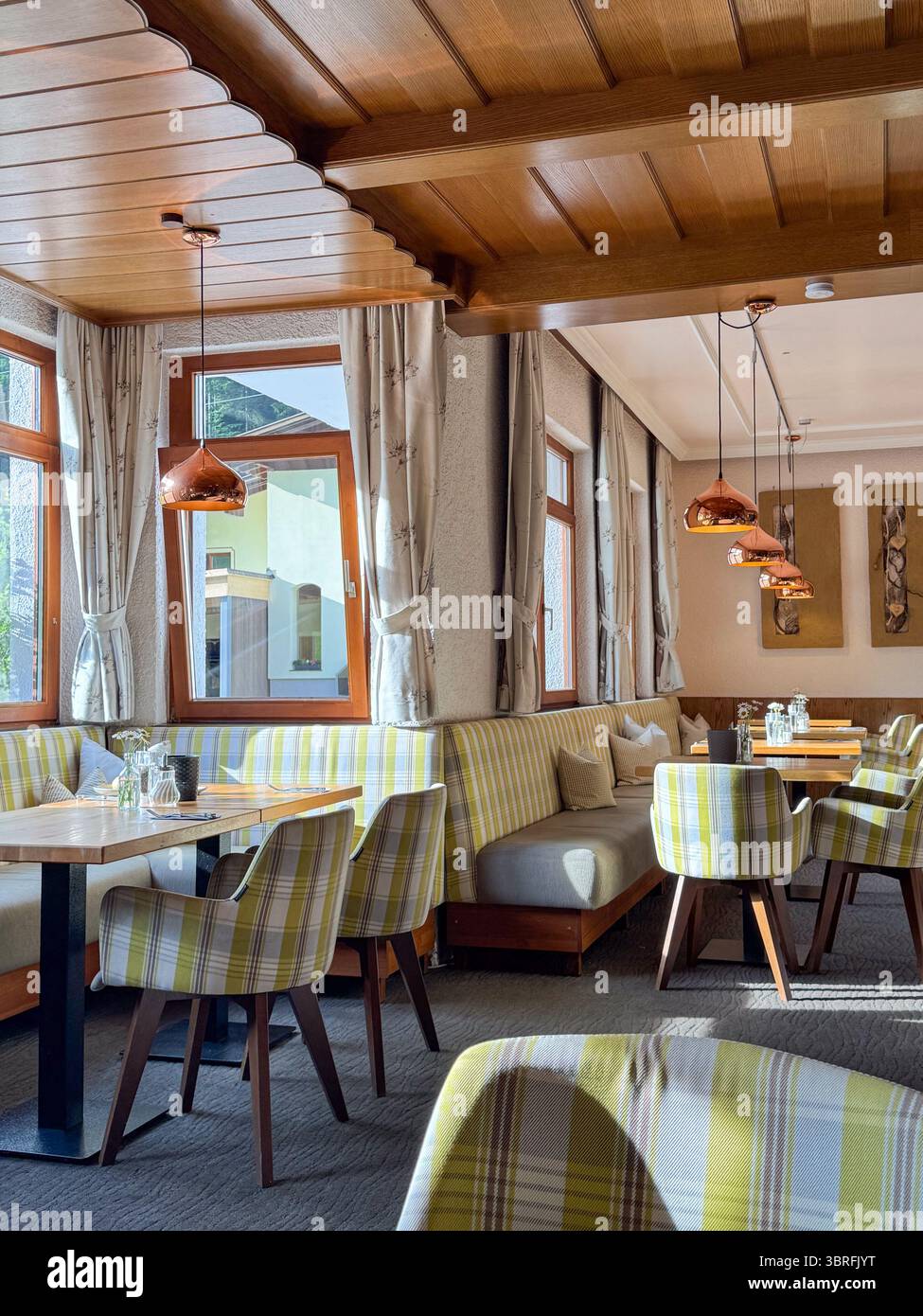 Bright restaurant interior featuring cozy booths with plaid chairs ...