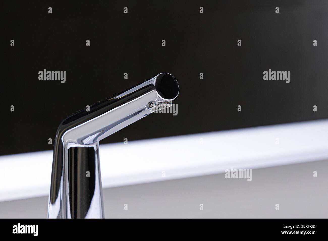 A sleek, touchless chrome tap touchless installed on a contemporary ...
