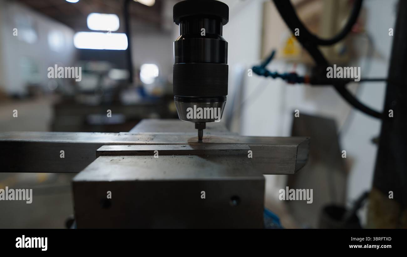 Automated drill press making holes in metal bar within a factory ...