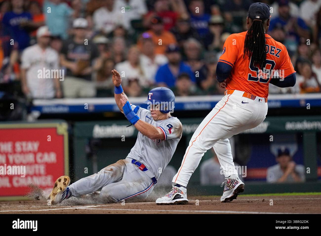 Texas Rangers' Sam Haggerty, left, scores on a wild pitch thrown by ...