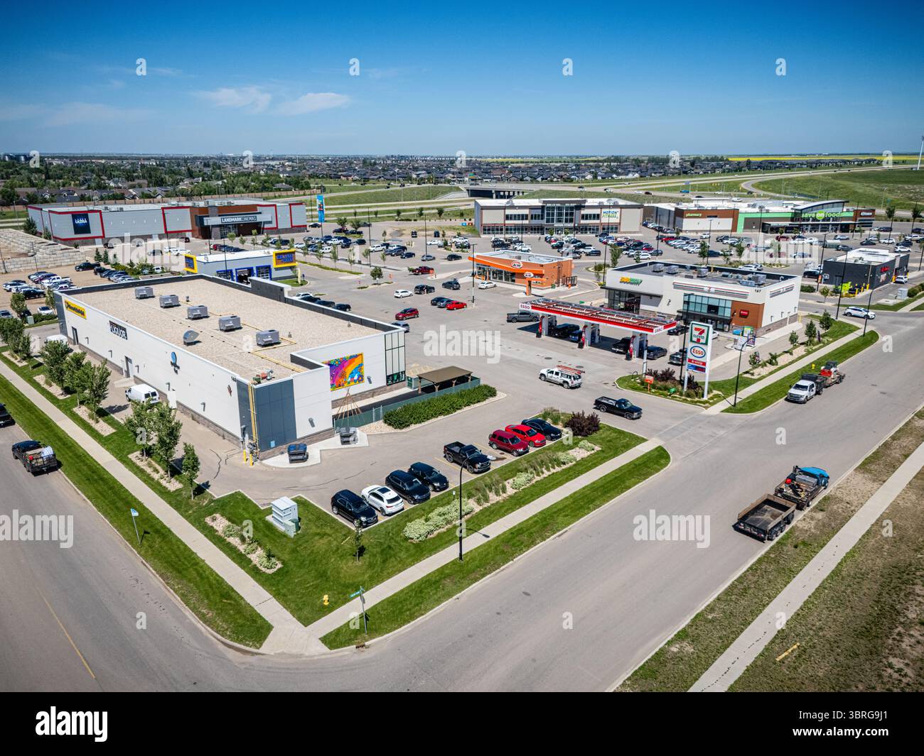 Large shopping mall with a lot of cars parked in the lot. The mall is ...