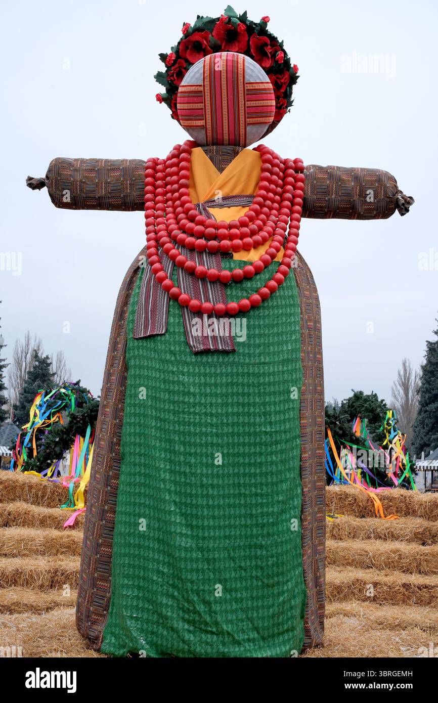 A towering festival figure dressed in colorful attire stands proudly ...