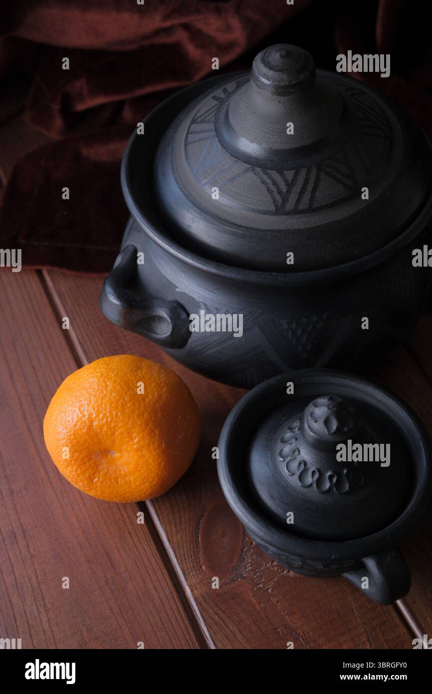 Black clay pottery displays intricate designs alongside a vibrant ...