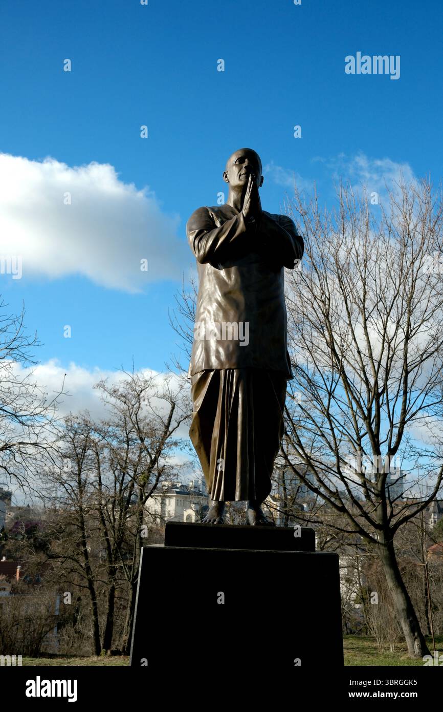A serene statue stands with joined hands, reflecting tranquility and ...