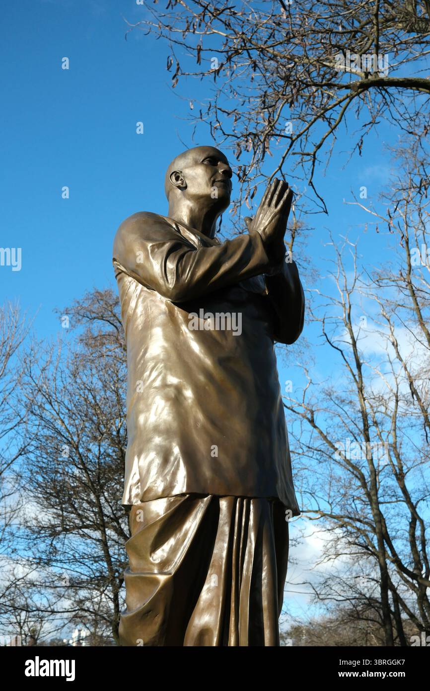 Bronze statue showing a figure in a prayer pose surrounded by trees ...
