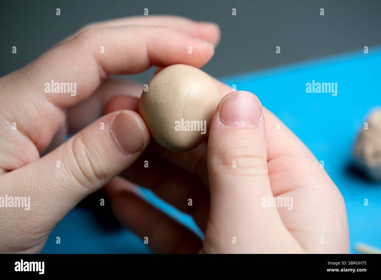 Hands mold a small ball of clay, showcasing artistic playfulness and ...