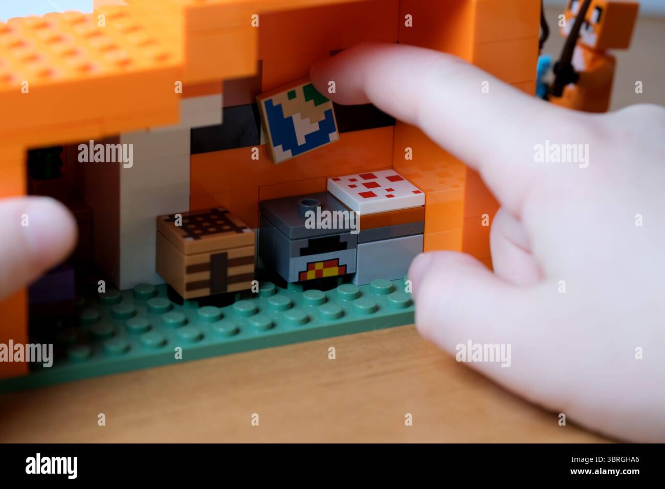 A child's hands carefully arrange colorful blocks to create a kitchen ...