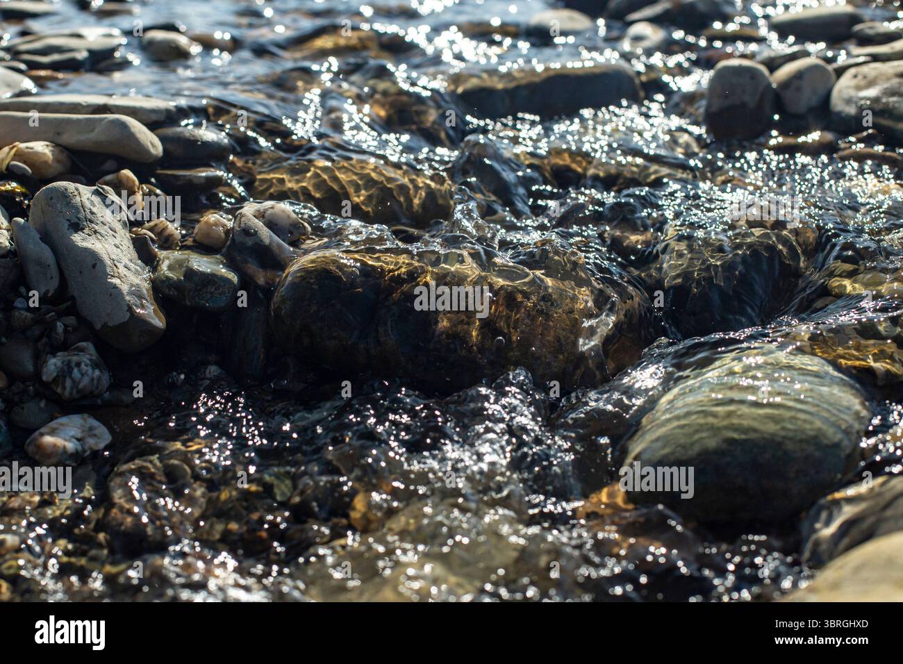 Rapid water stream river close up with sunlight Stock Photo - Alamy