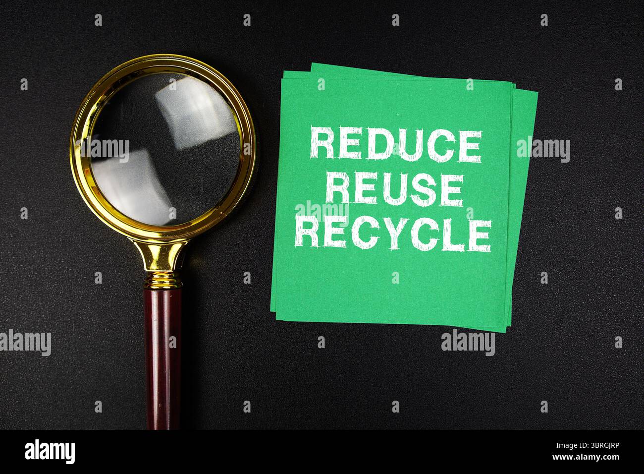 Reduce Reuse Recycle text on sticky note with magnifying glass on black ...
