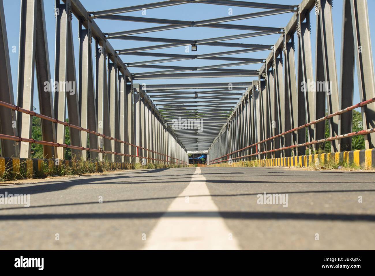 Asphalt road in the corridor of Vintage Steel Bridge Structure with ...