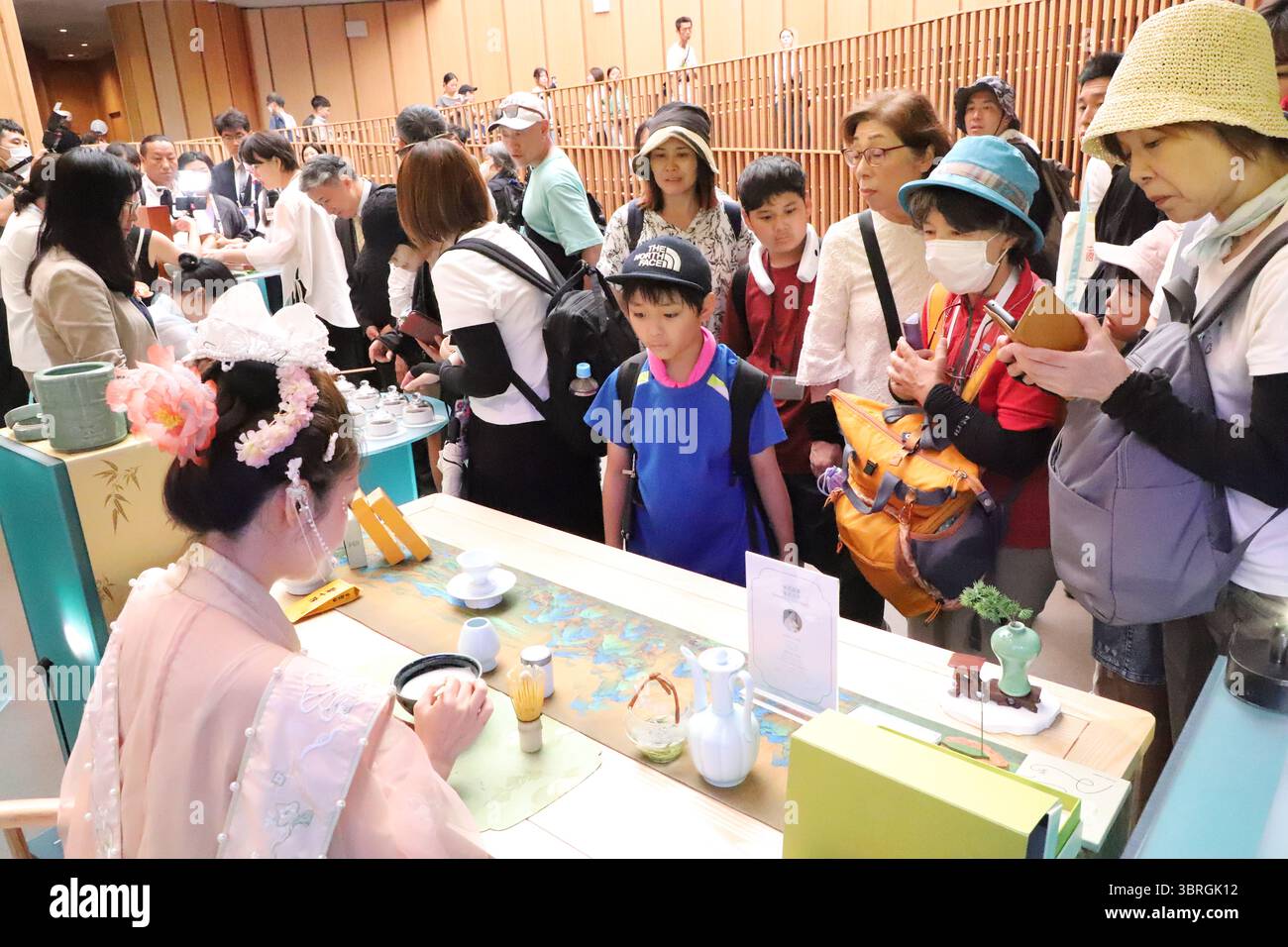 Beijing, Japan. 12th July, 2025. People watch a tea art display at the ...