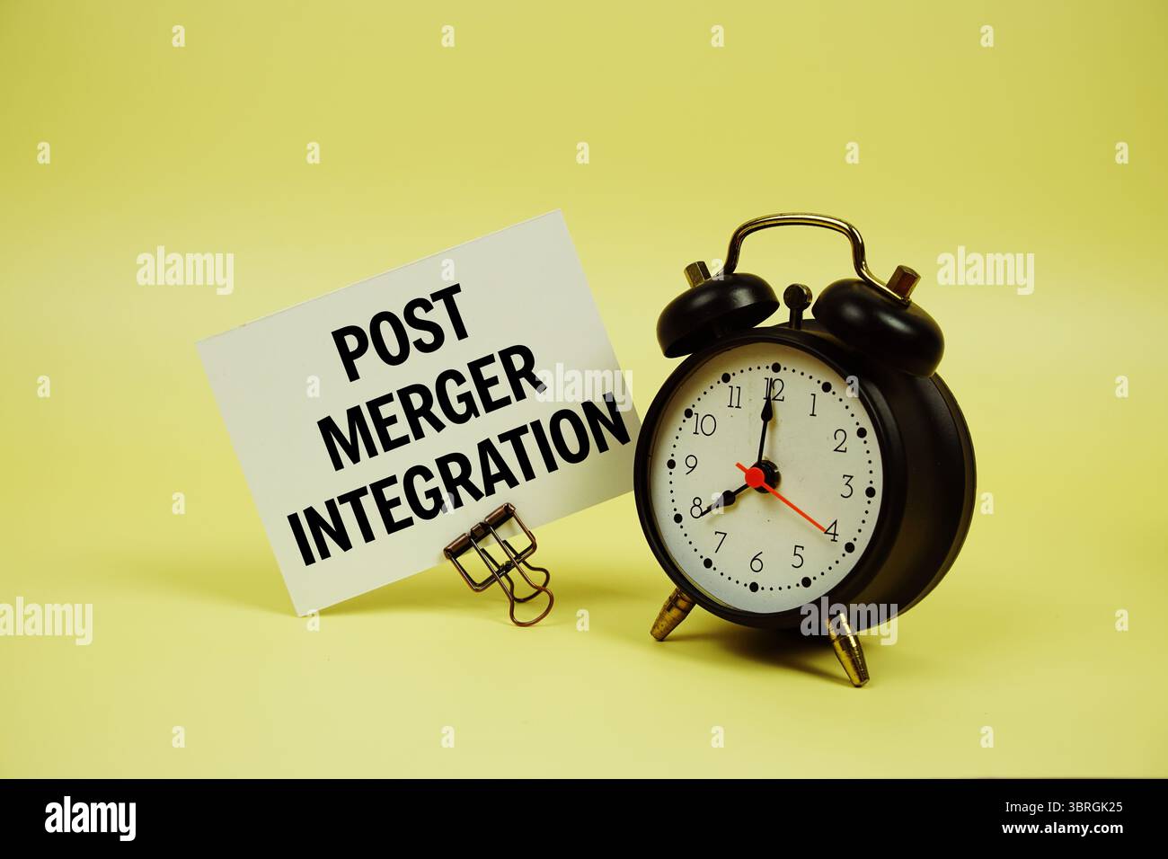 Post Merger Integration text message on paper card with alarm clcok on ...