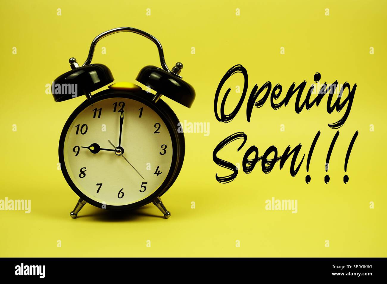 Opening Soon text with alarm clock on yellow background Stock Photo - Alamy