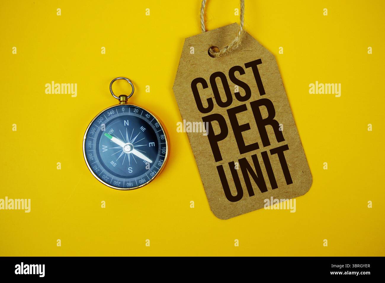 Cost Per Unit text on price tag with compass on yellow background Stock ...
