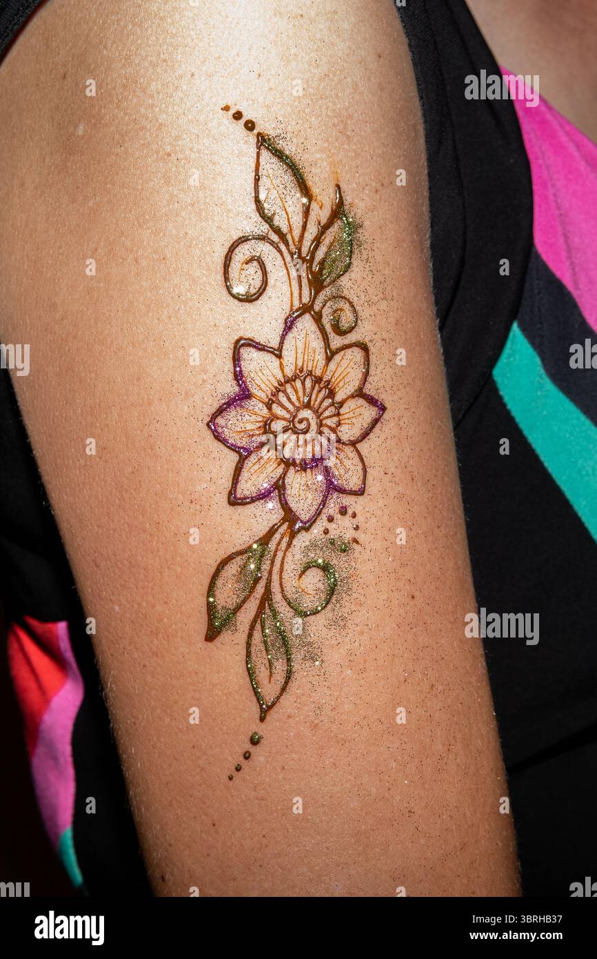 A floral Henna design on a woman's upper arm applied during a pre ...
