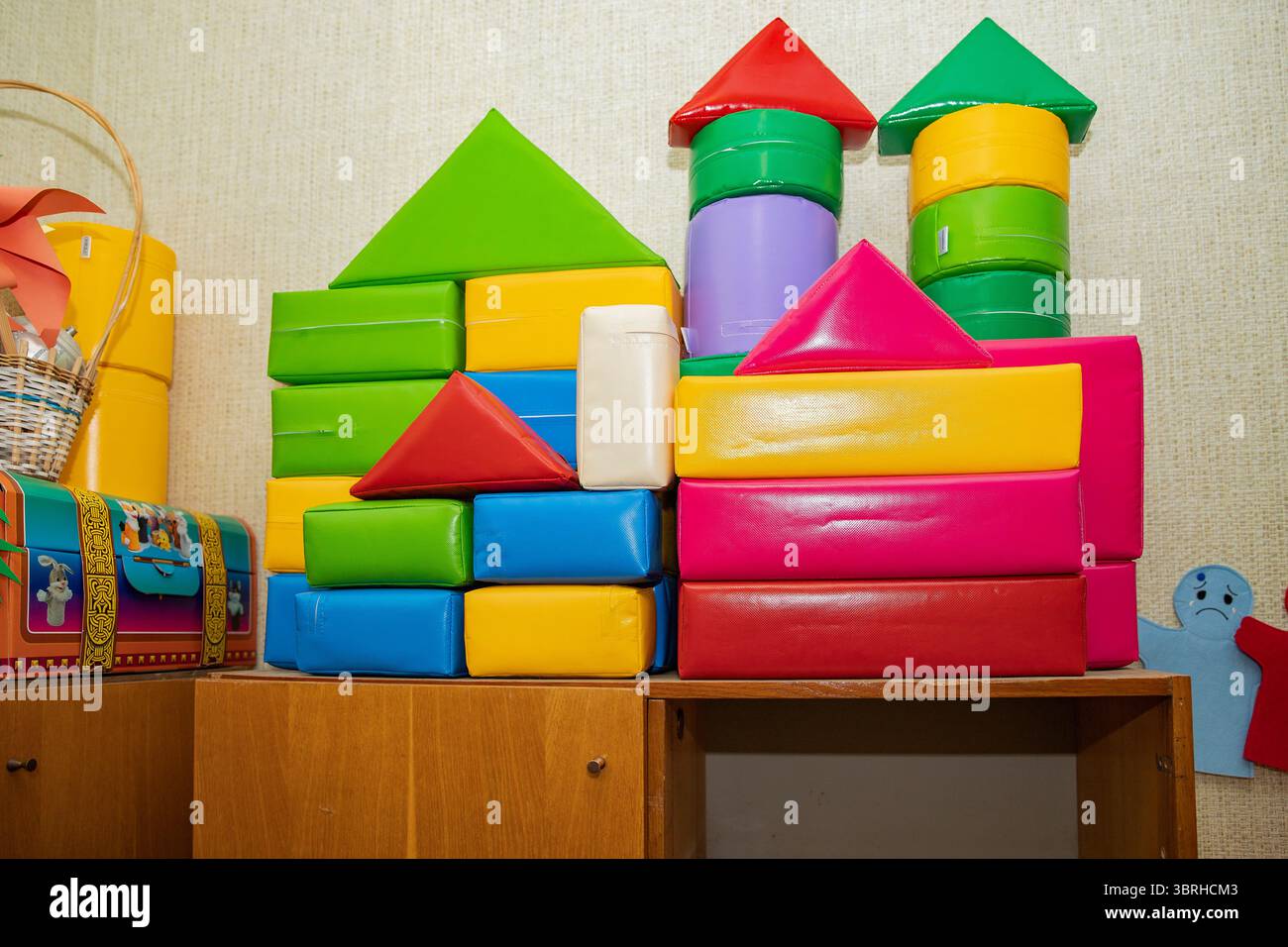 Brightly colored soft blocks stacked in shapes of houses and towers ...