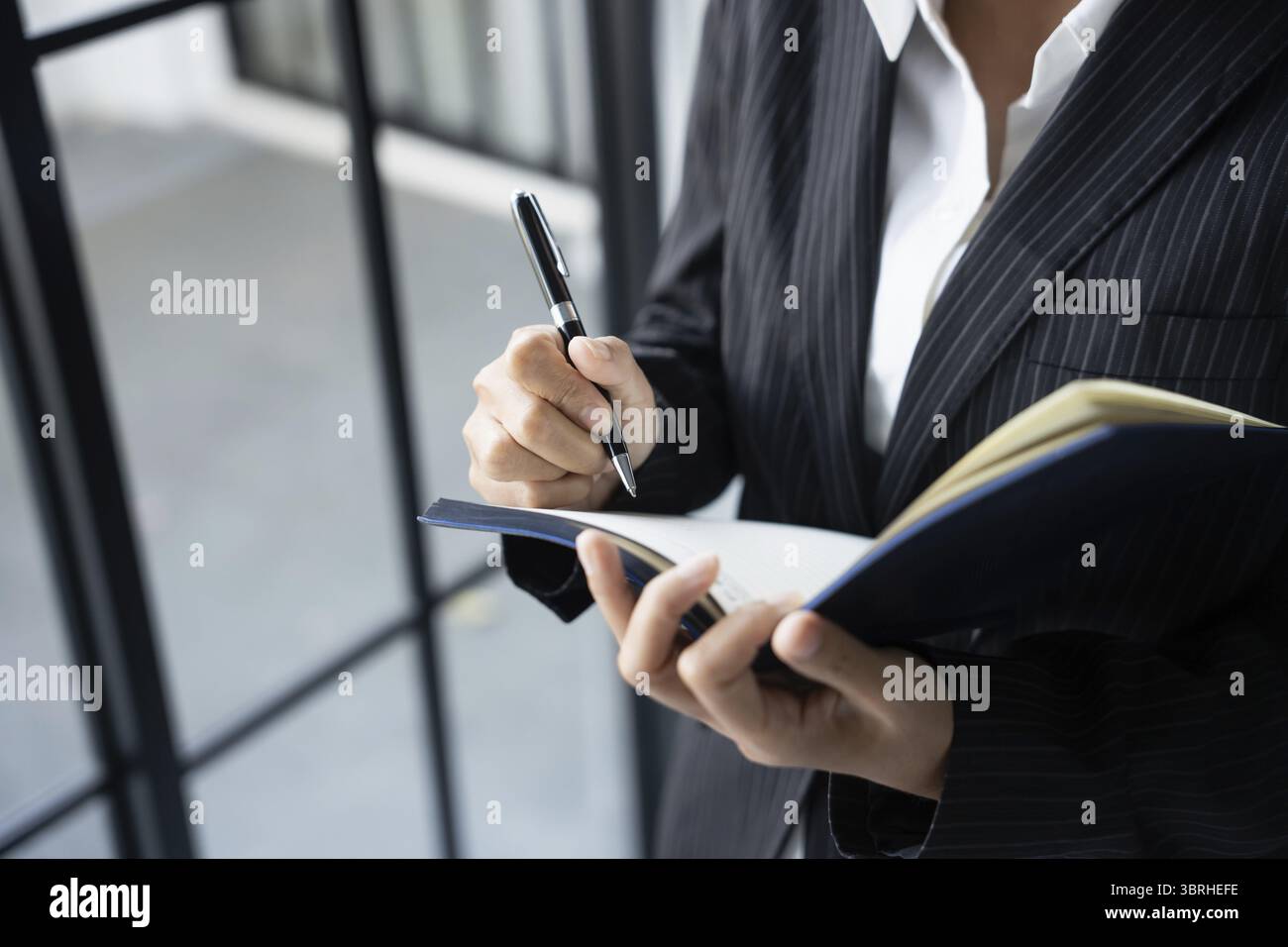 Business woman working from office taking reading and writing notes in ...