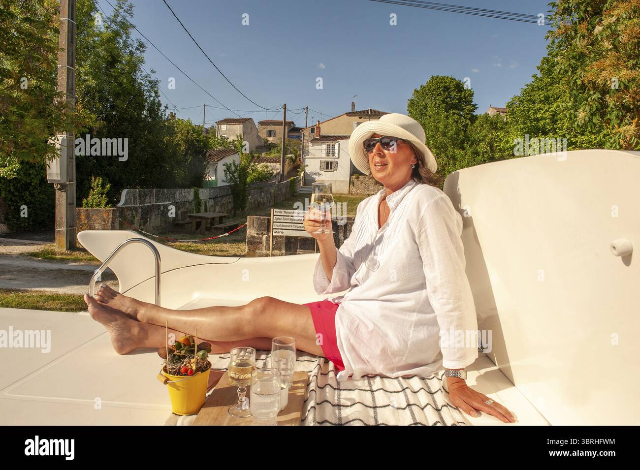 Woman relaxing with French savoir-vivre on a modern houseboat, enjoying ...